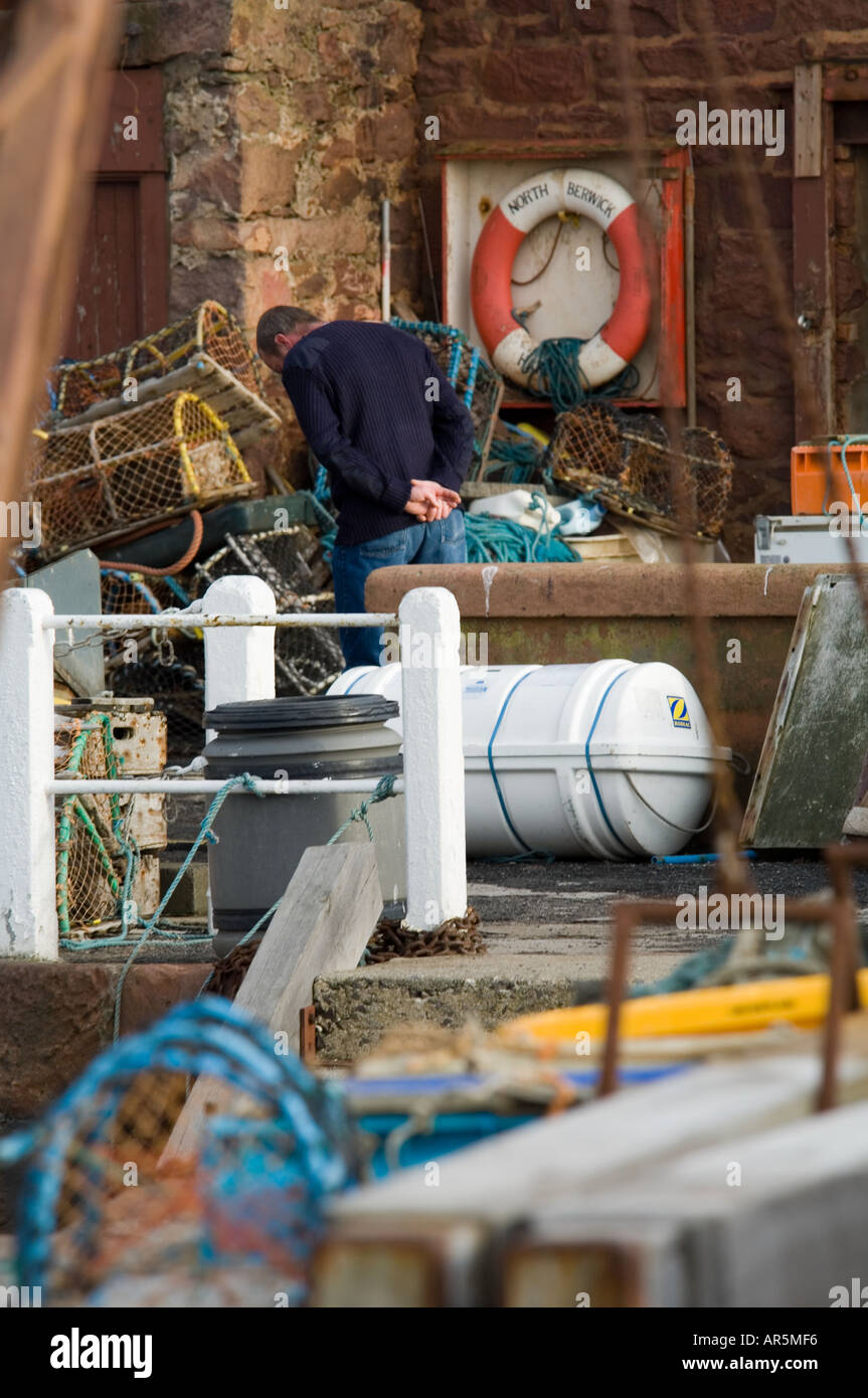 Man browsing among maritime objects in North Berwick harbour Scotland ...