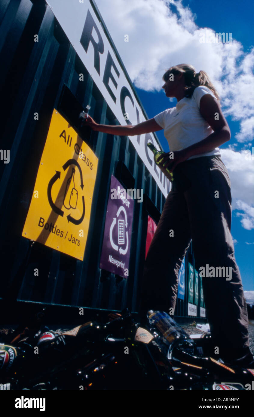 Person using a roadside recycling station (depository) showing signage ...