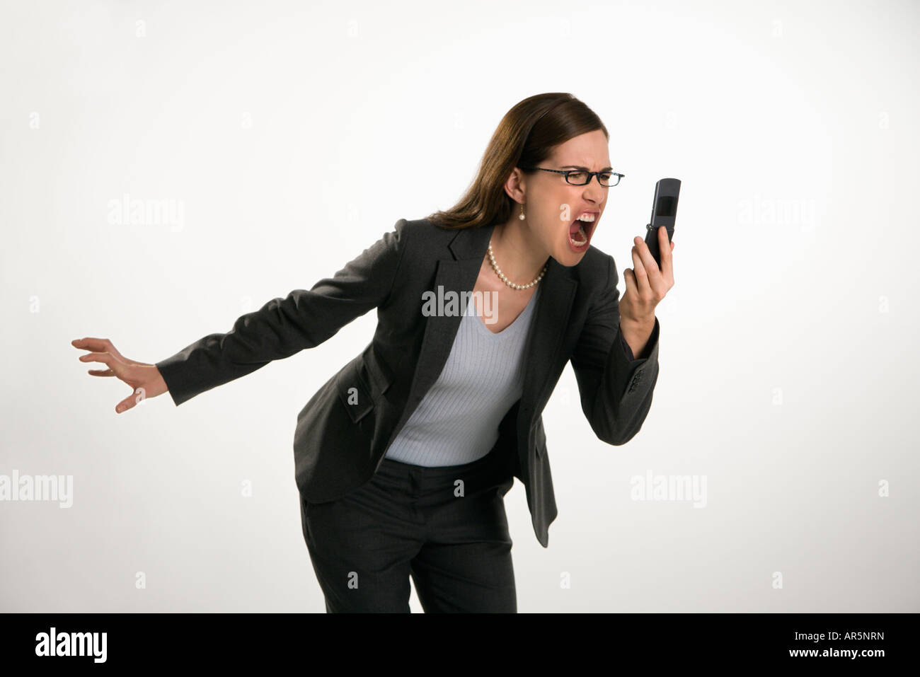 Caucasian mid adult professional business woman yelling into cell phone ...