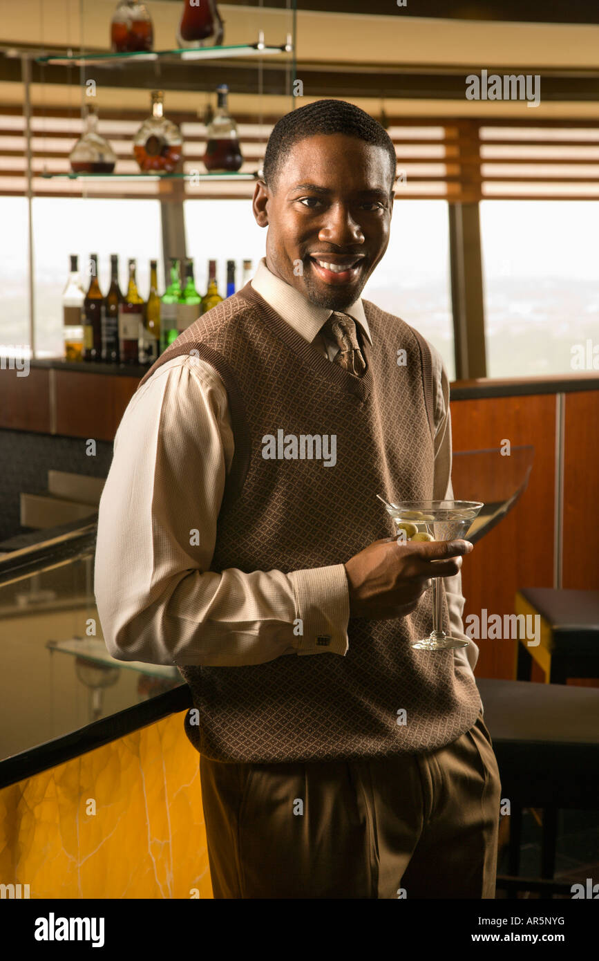 African American mid adult man at bar with martini smiling at viewer ...
