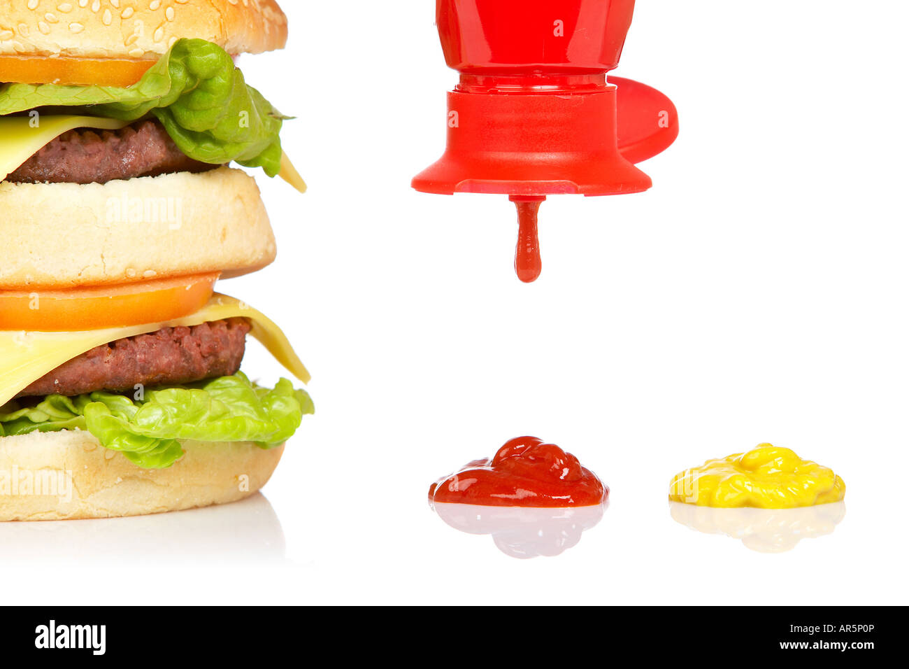 Double cheeseburger mustard and pouring ketchup Stock Photo - Alamy