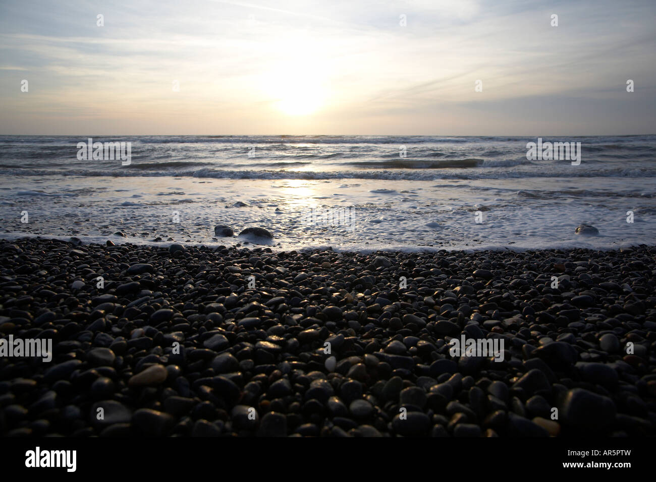 Sunset on shingle beach in North Wales Stock Photo - Alamy