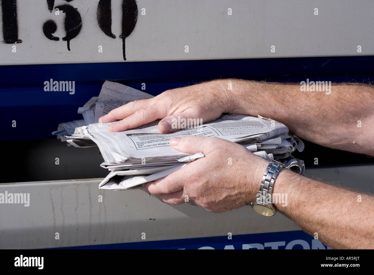 Close up of senior mans arms throwing newspaper into recycle bin Stock ...