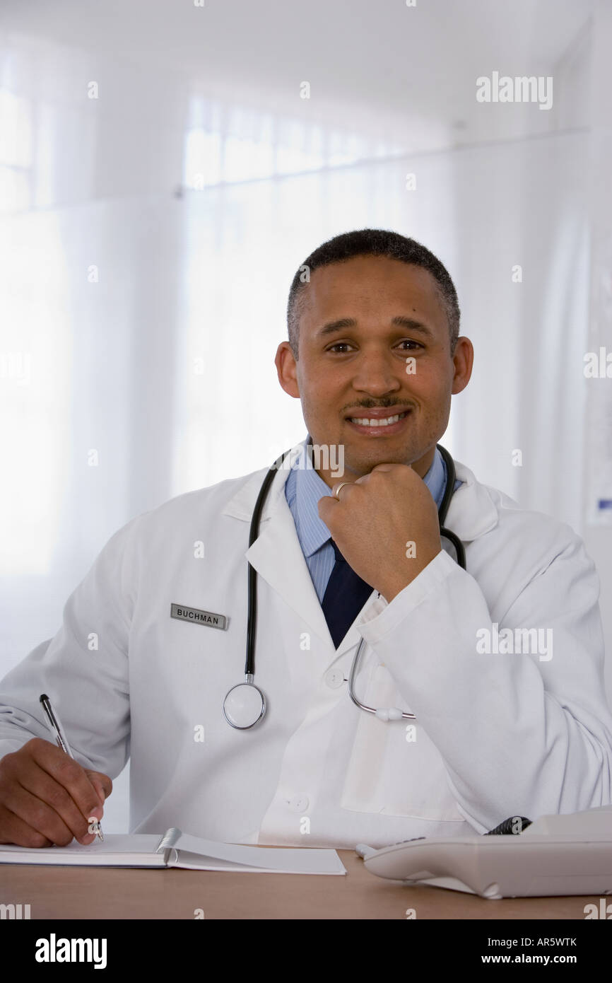 African doctor writing in notebook Stock Photo - Alamy