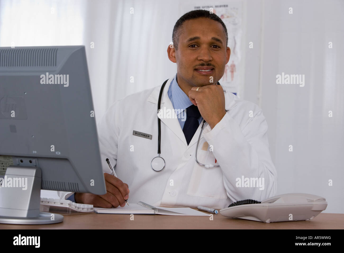 African doctor writing in notebook Stock Photo - Alamy
