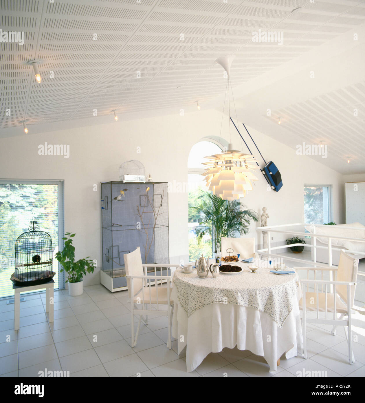 Birdcage and aviary in seventies dining room with white tiled floor and ...