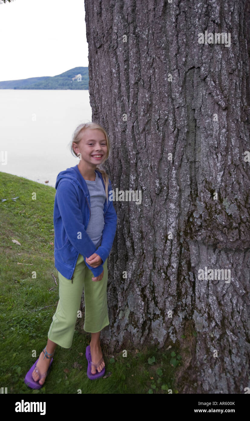 Child standing next to a tree Stock Photo - Alamy
