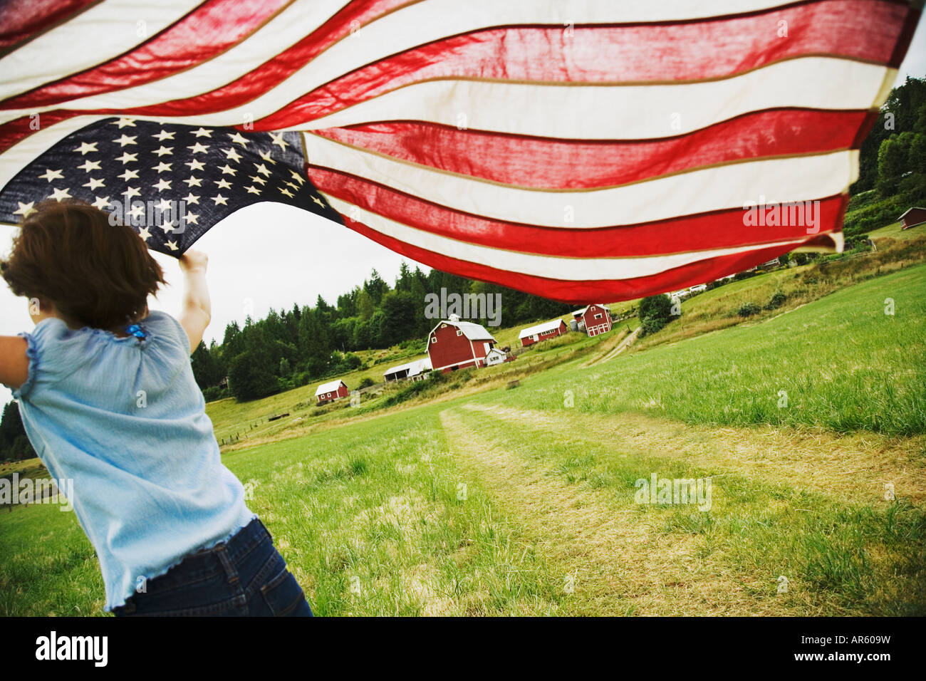 Girl running with American flag on farm Stock Photo - Alamy