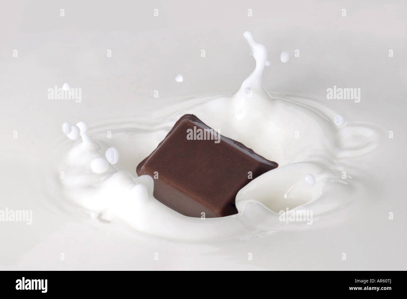 Chocolate falling into milk. Drops splashing around Stock Photo - Alamy
