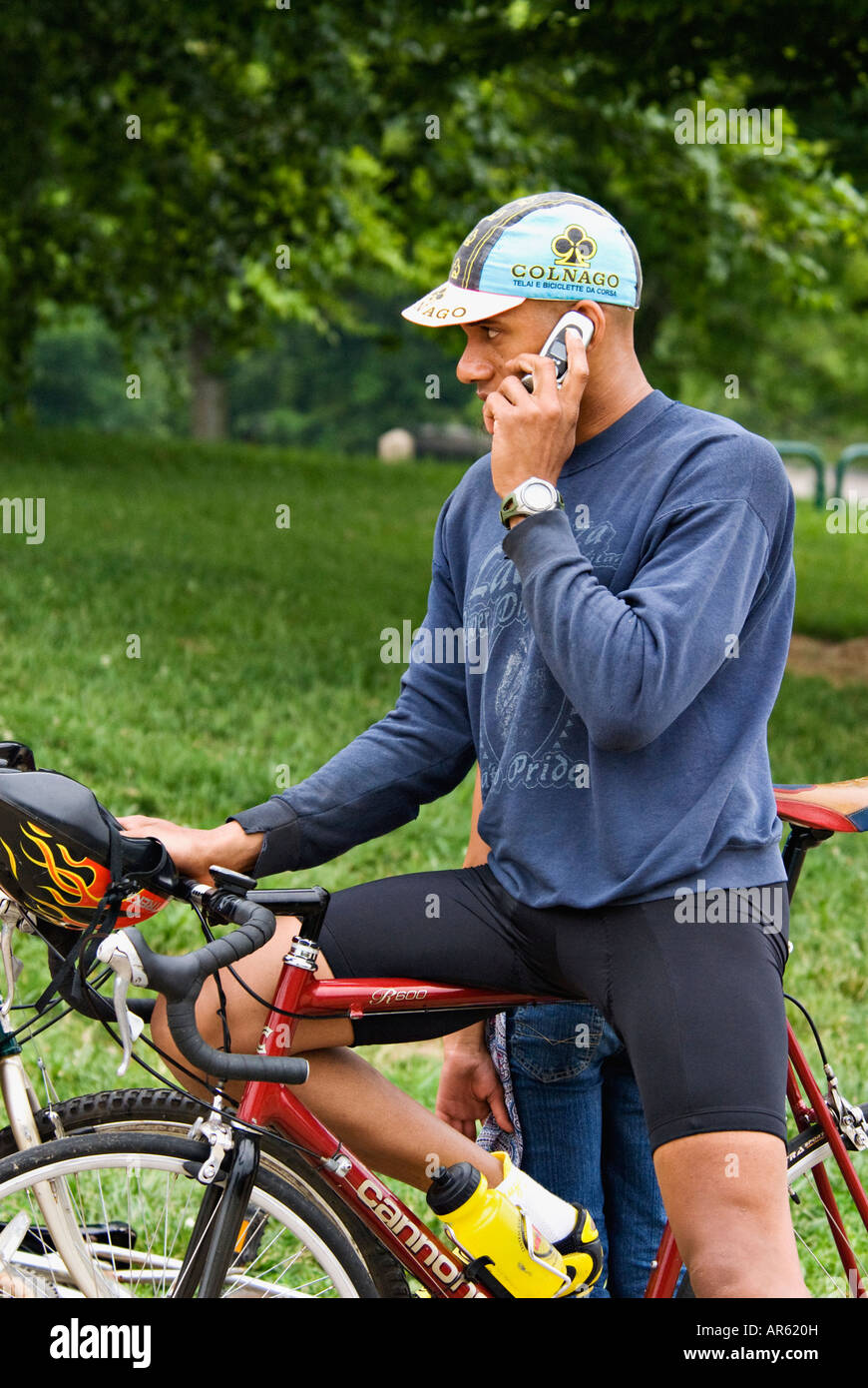 Man on Bike Using Cell Phone Stock Photo - Alamy