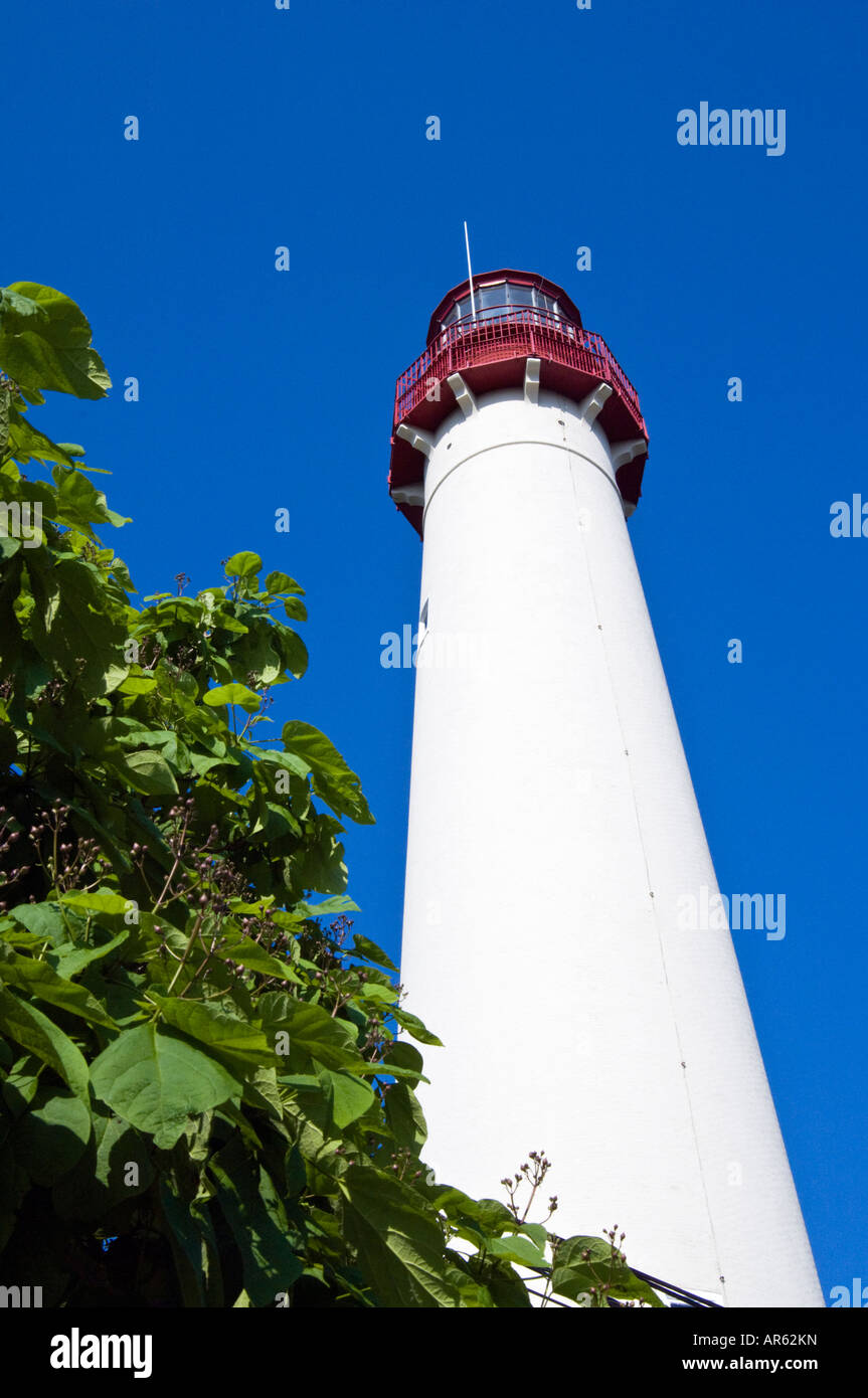 White lighthouse with red roof and railing around latern room against ...