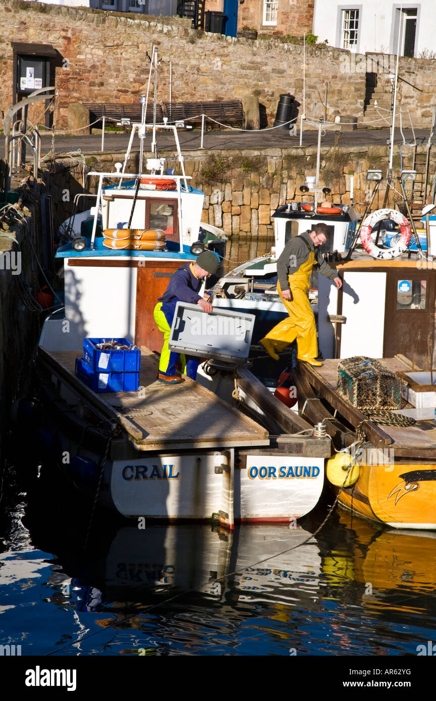 Fishermen working in their boats at Crail harbour East Neuk of Fife ...