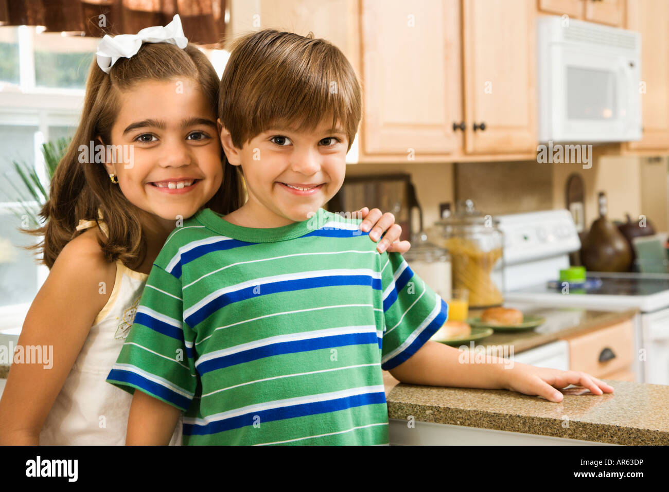Hispanic children in kitchen smiling at viewer Stock Photo - Alamy