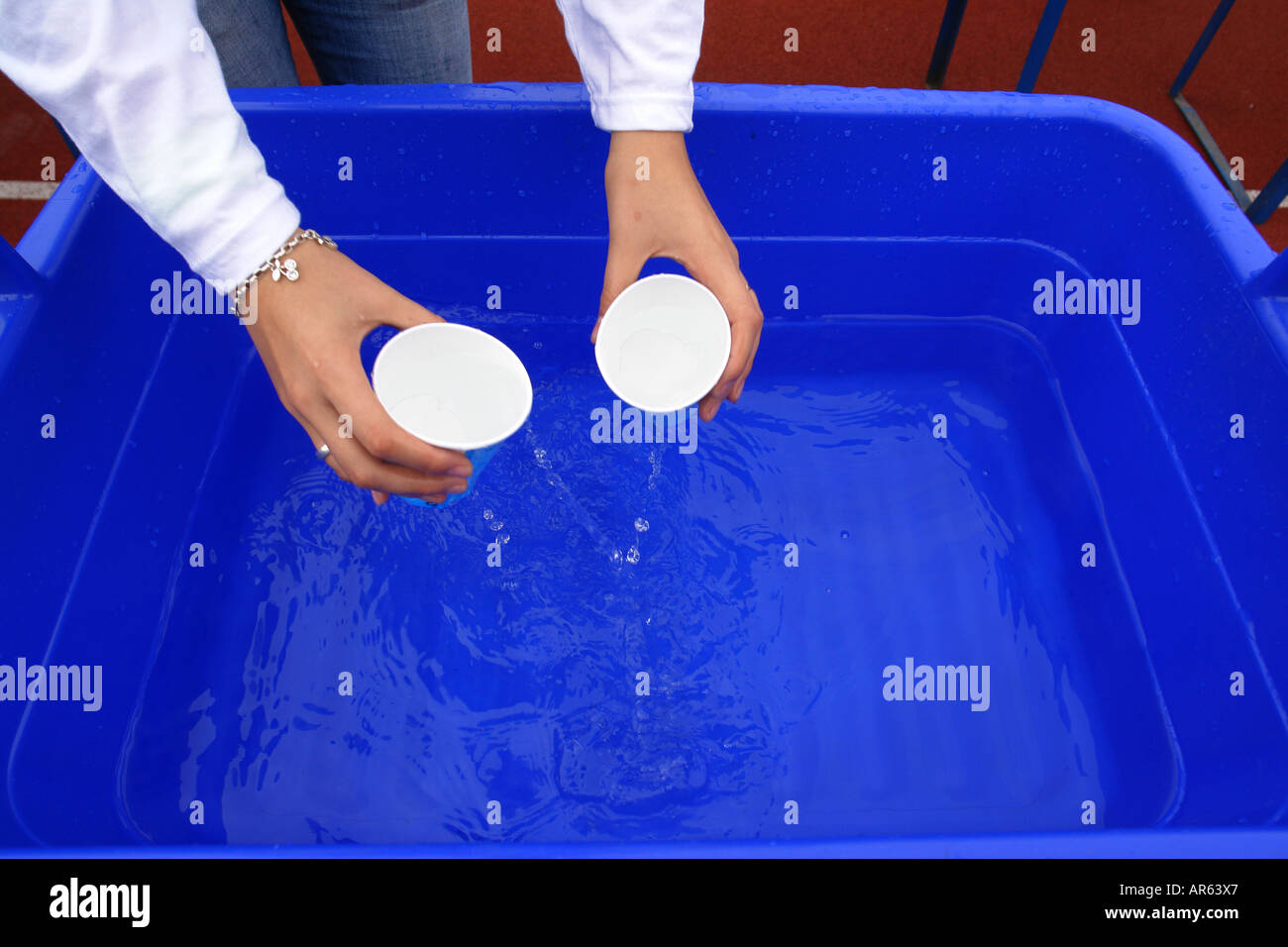Filling up cup of water Stock Photo - Alamy