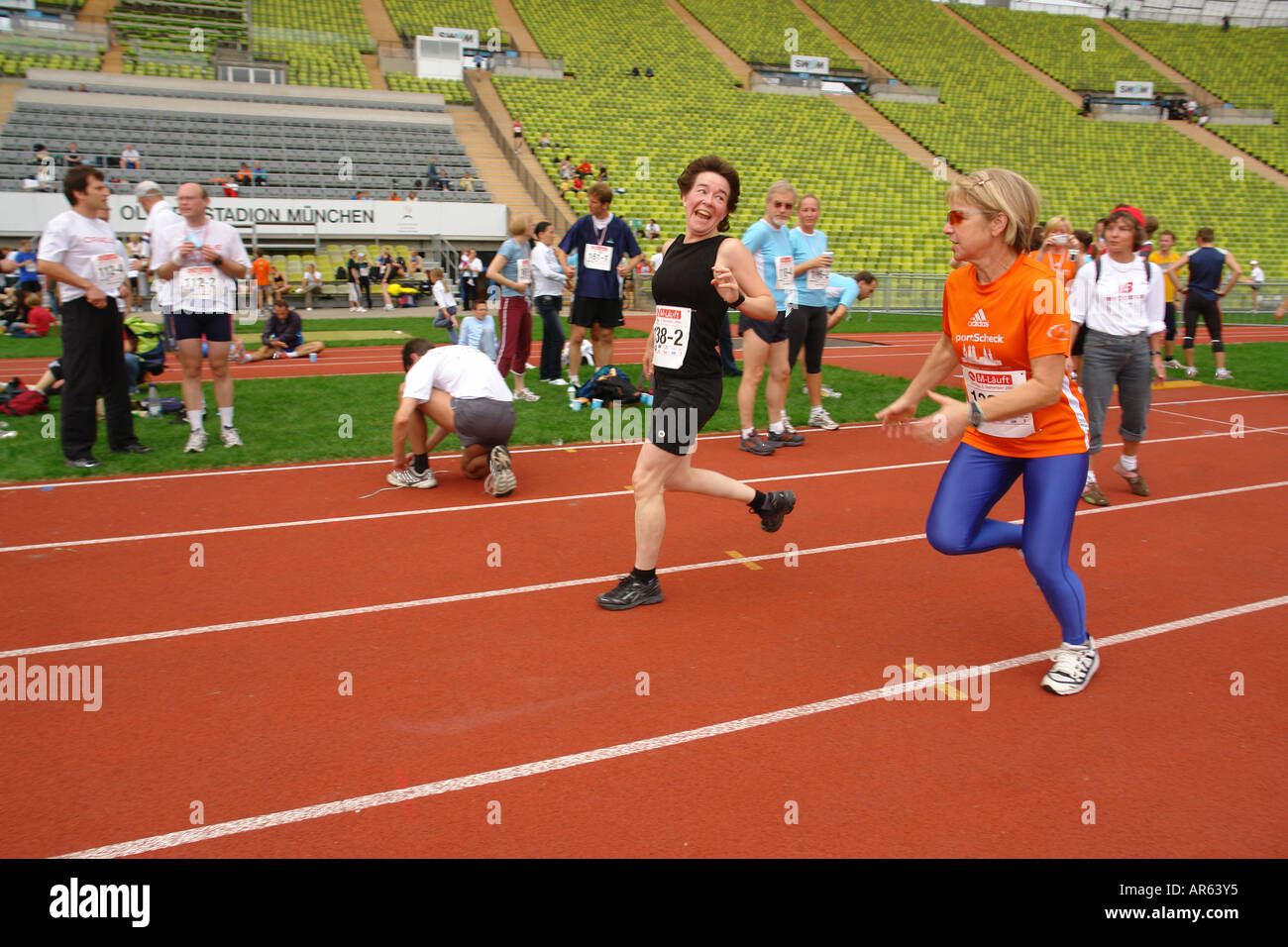 Runners run a relay race at stadium Stock Photo - Alamy