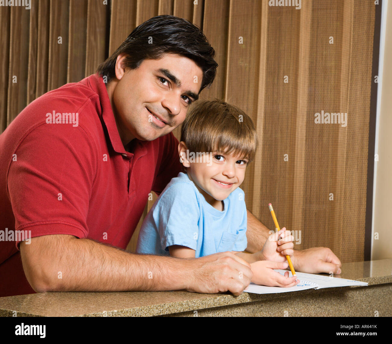 Hispanic father and son smiling at viewer with homework Stock Photo - Alamy