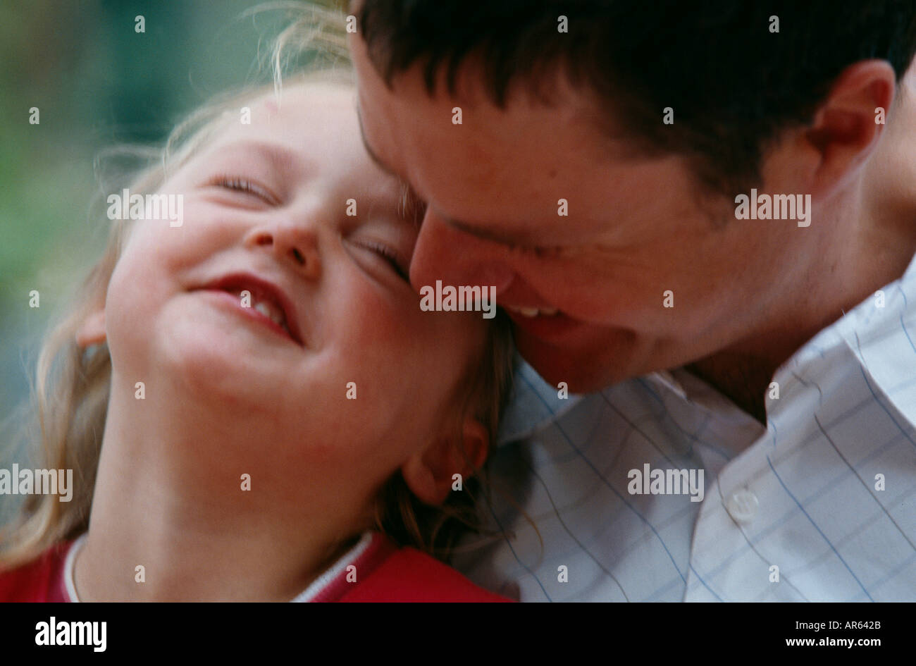 Father with short brown hair smiling looking down at female child ...