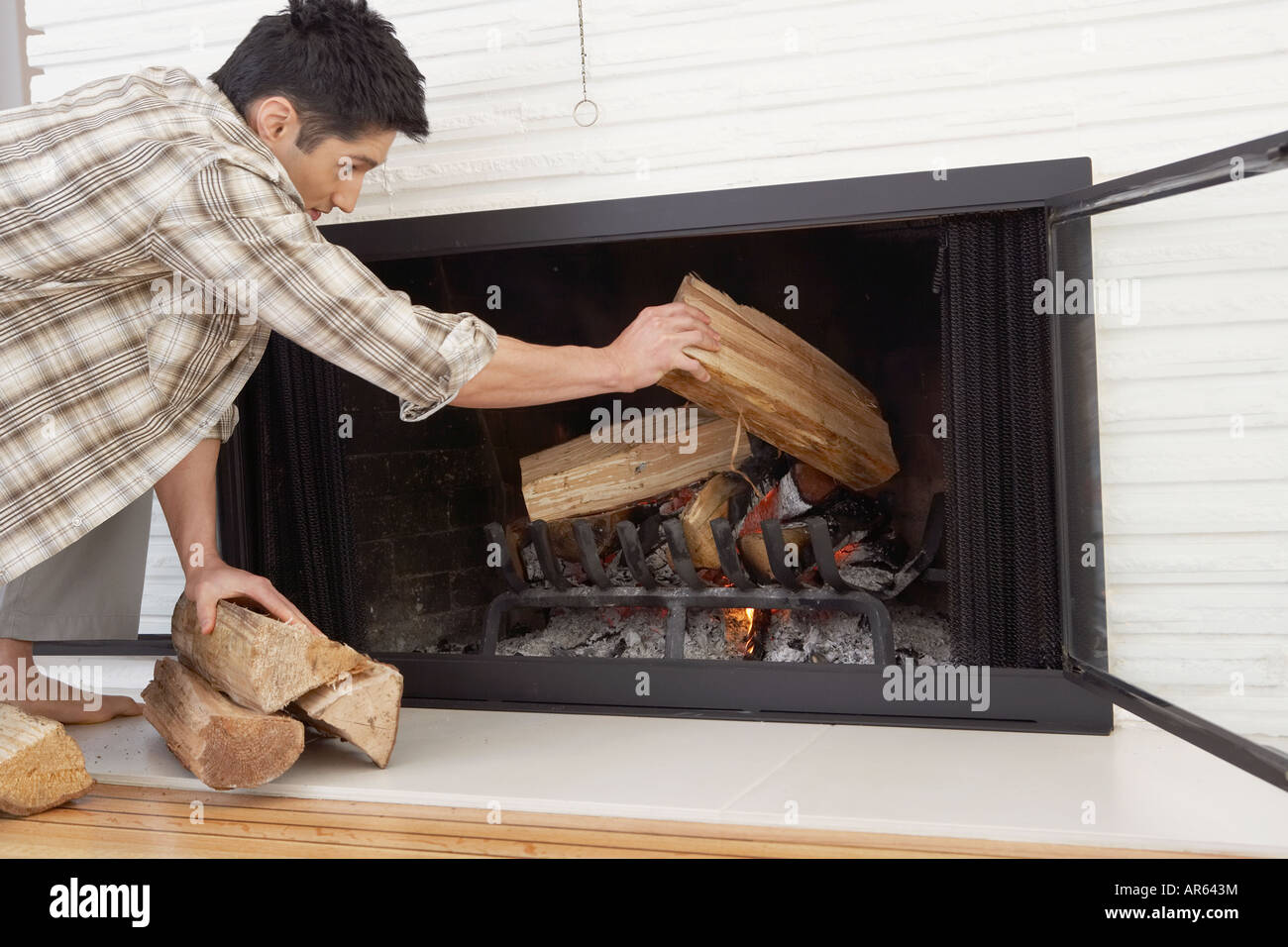 Fireplace adding wood fire hi-res stock photography and images - Alamy