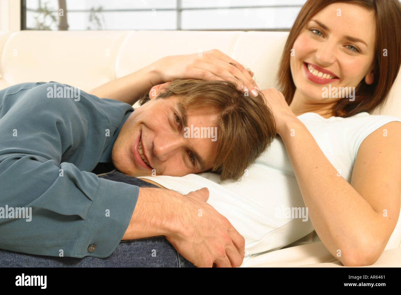 Loving couple lying on sofa male with head in her lap both happy ...