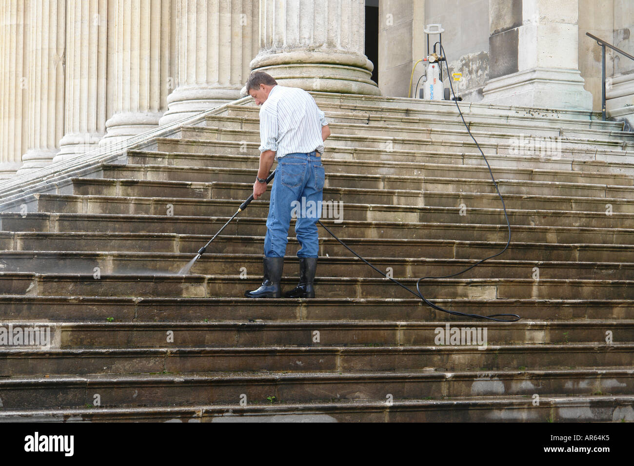 Worker using water compressor to clean steps Stock Photo - Alamy