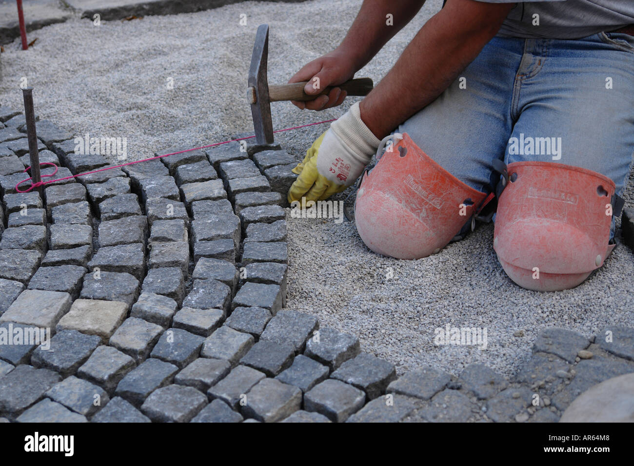 Cobblestone Bricklayer work on the pavement road Stock Photo - Alamy