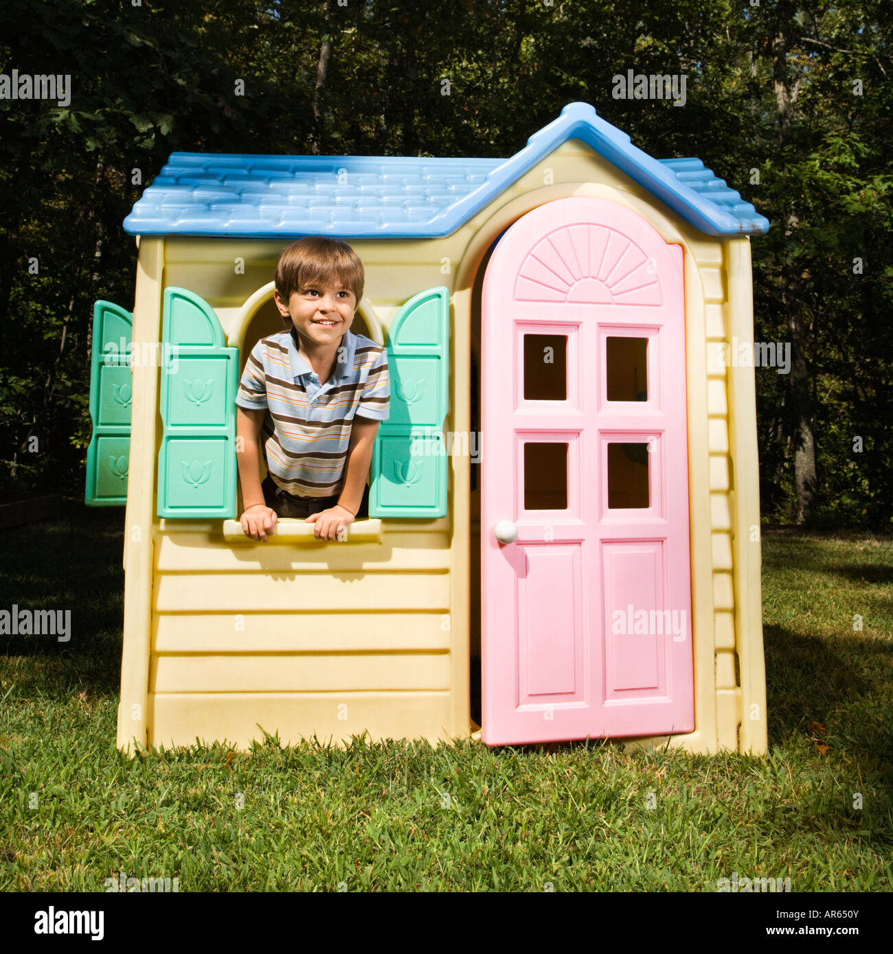 Hispanic boy in window of outdoor playhouse smiling at viewer Stock ...