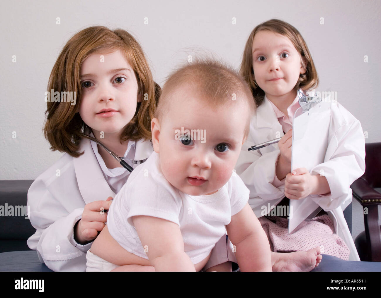Three little girls playing doctor high key Stock Photo - Alamy