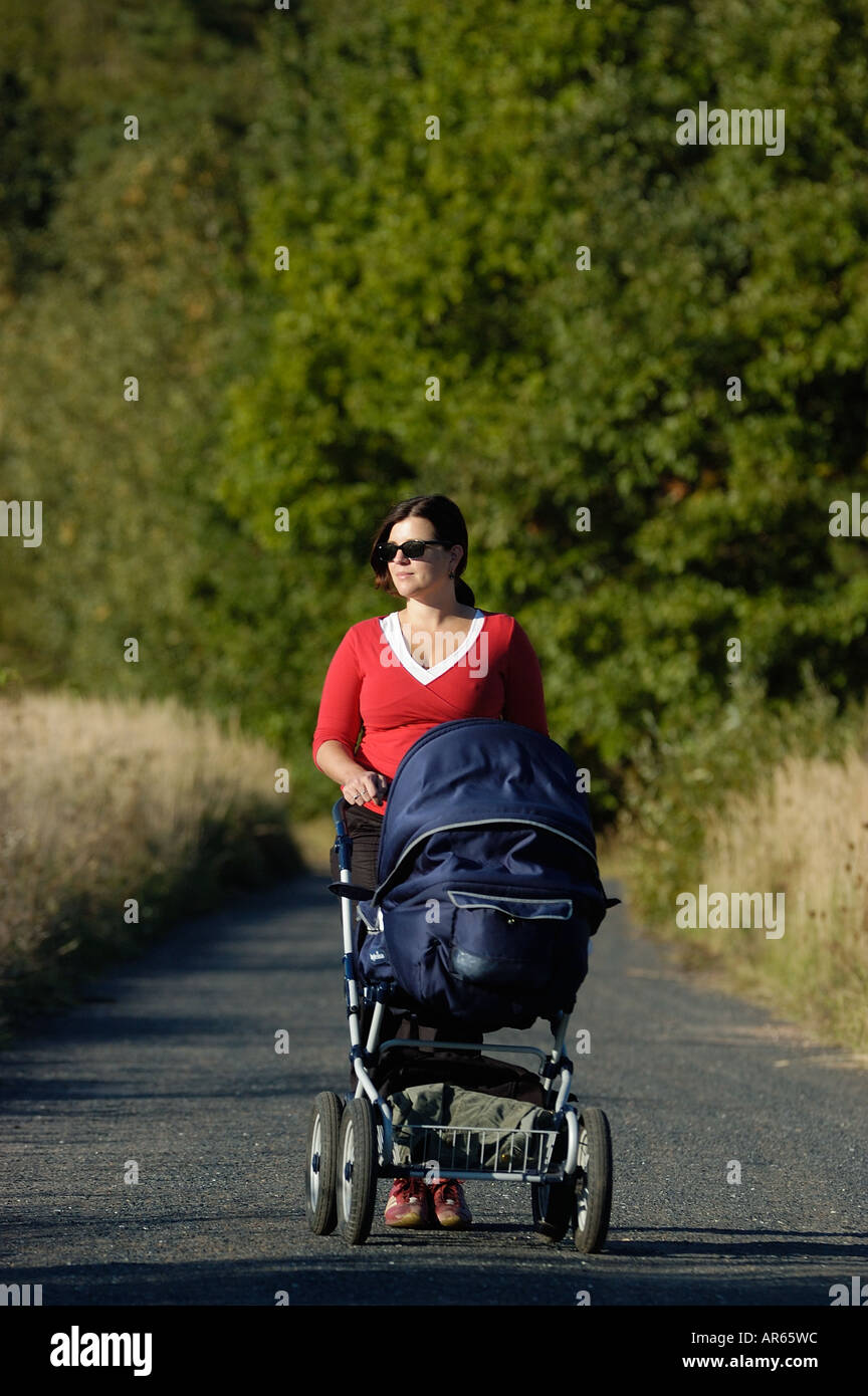 Portrait of a young woman pushing a baby pram on the trip Stock Photo ...