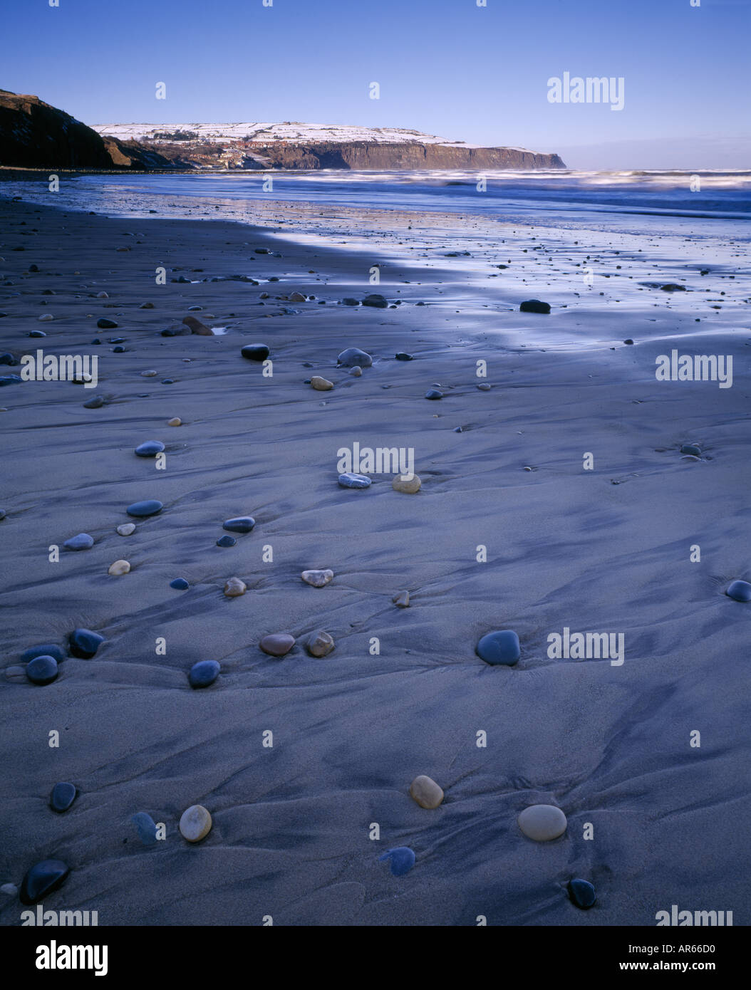 Robin Hoods Bay from the stone strewn beach looking North to the snow ...
