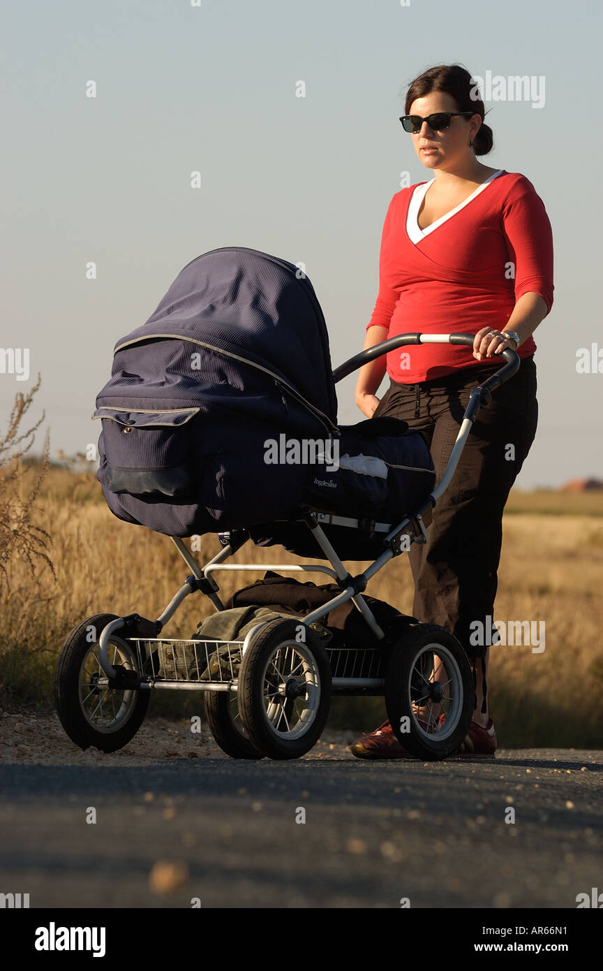 Portrait of a young woman pushing a baby pram on the trip Stock Photo ...