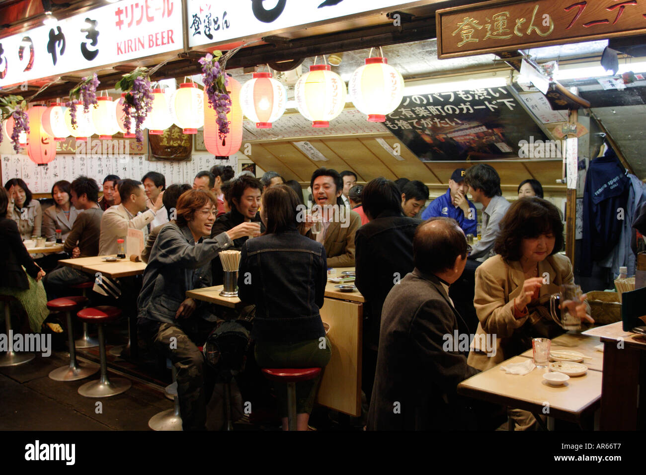 People sitting in a fast food restaurant at night, Yurakucho Yakitori ...