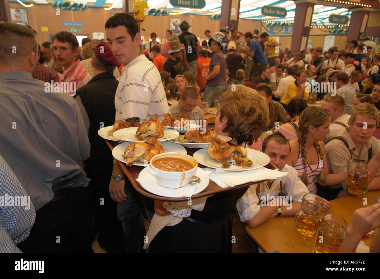 Server waitress carry tray of roasted chicken or roasted meat around in ...