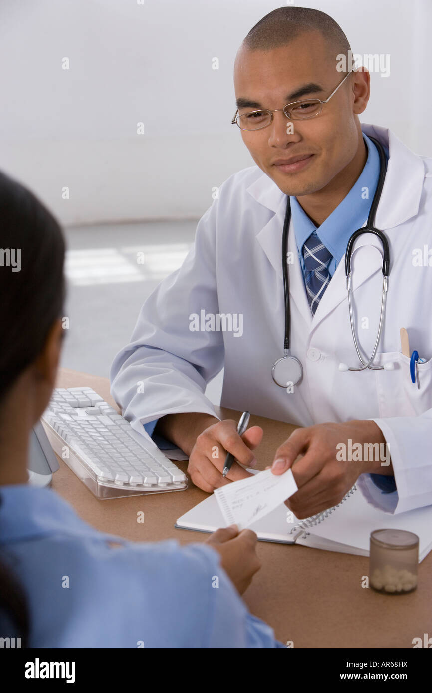 Male doctor handing prescription to patient Stock Photo - Alamy