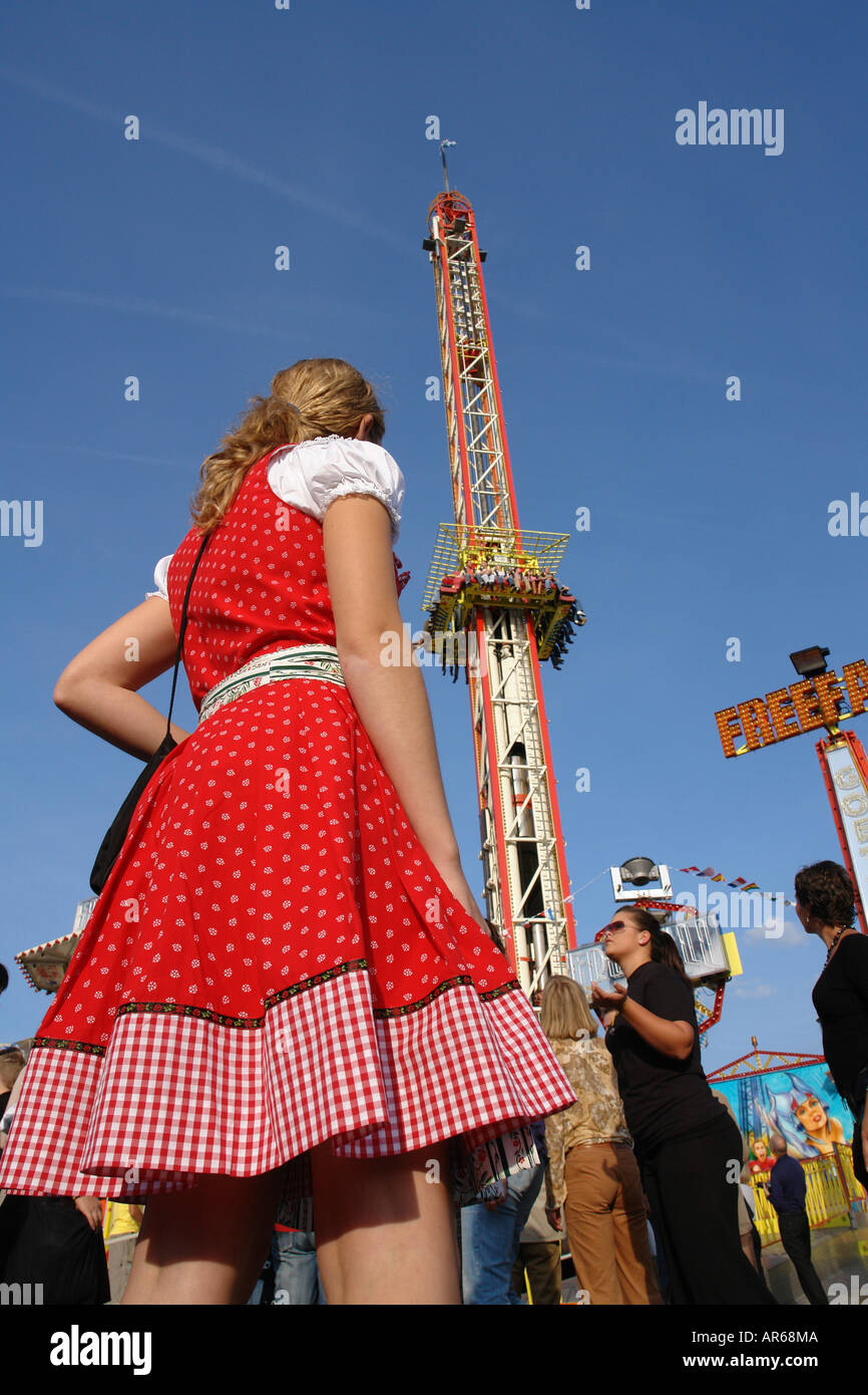 Girl in Dirndln watching Free fall machine game Oktoberfest in ...