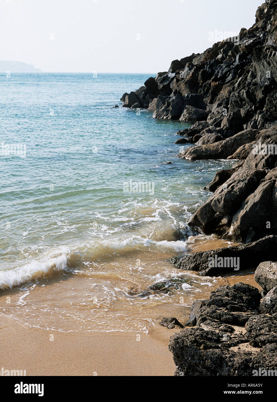 Rocky cliff onto beach Stock Photo - Alamy