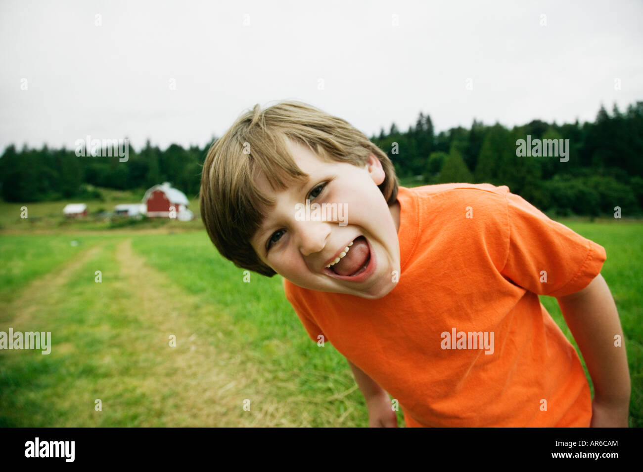 Boy laughing in farm field Stock Photo - Alamy