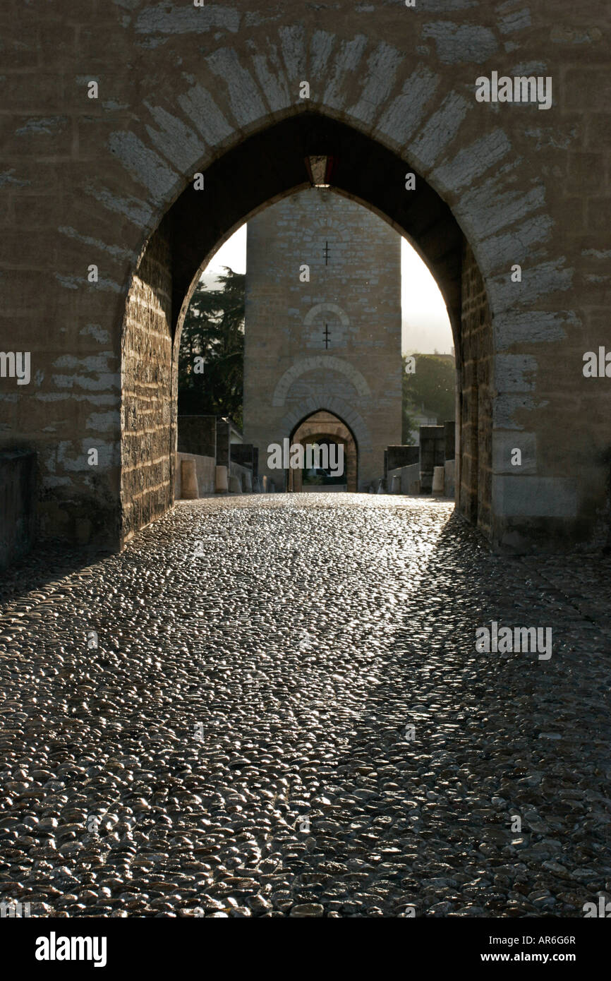 French medieval arched towers and cobbled road of the Valentre Bridge ...