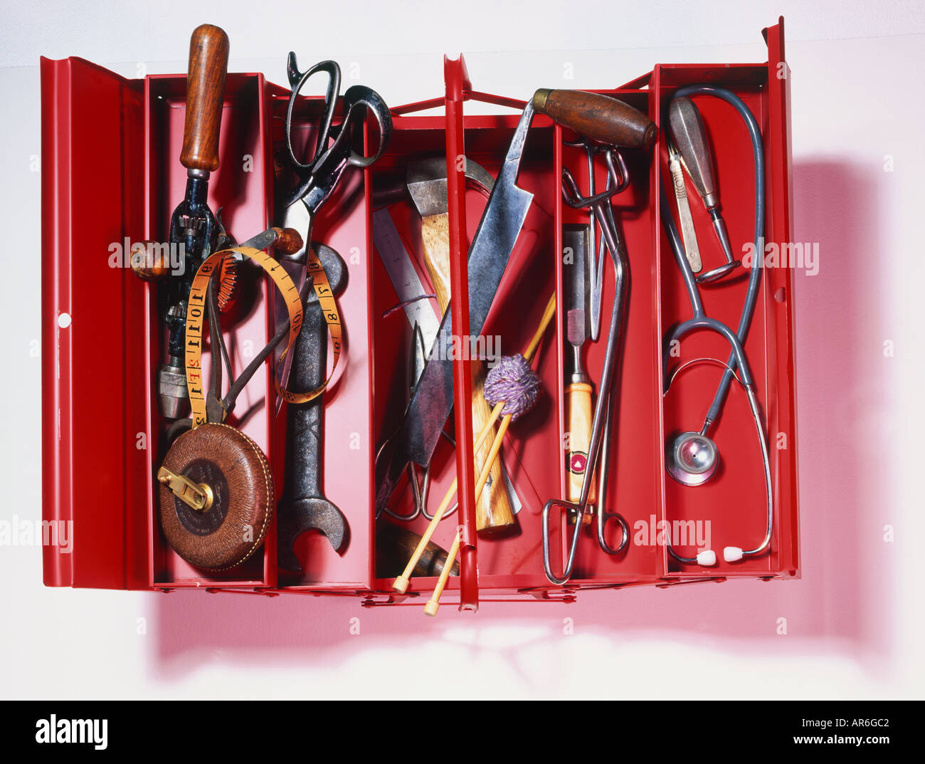 Red toolbox filled with assorted tools and other objects, opened out to ...