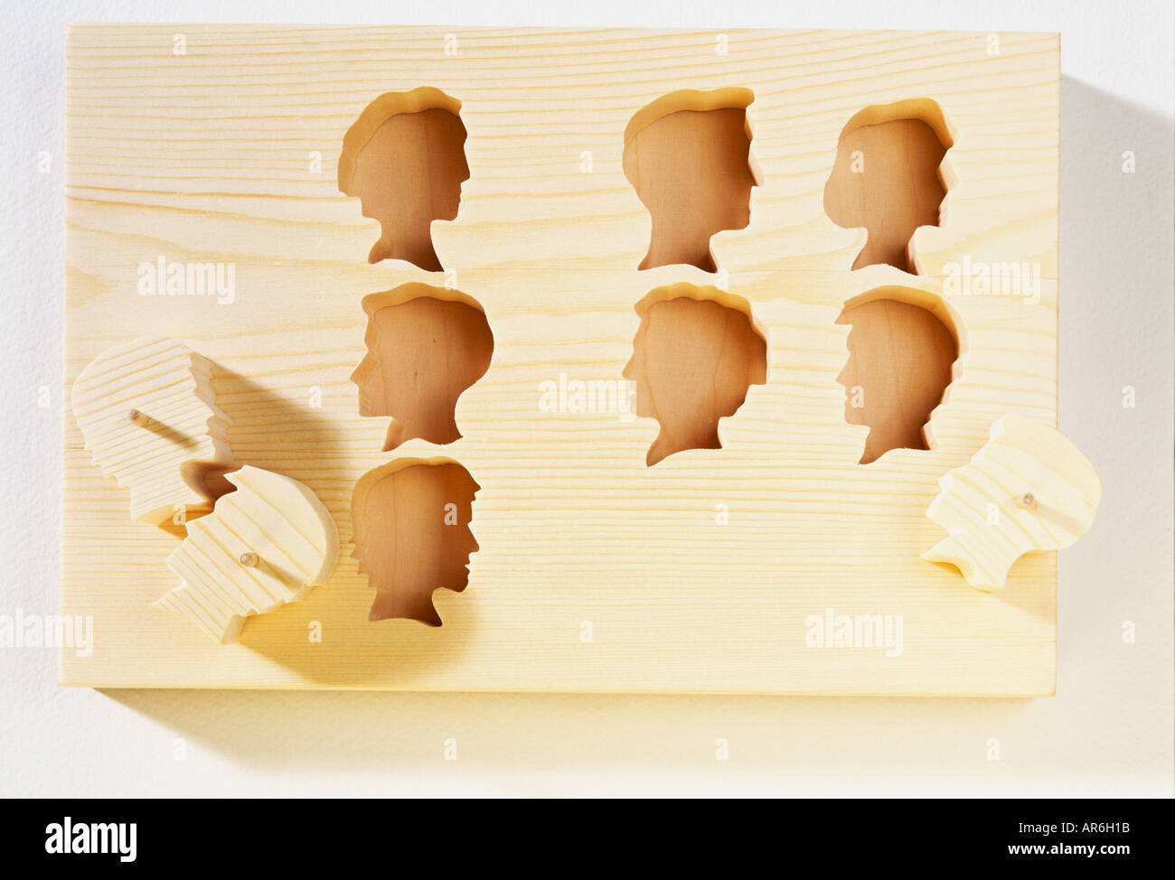 Rectangular piece of pale wood, male and female face profiles carved ...