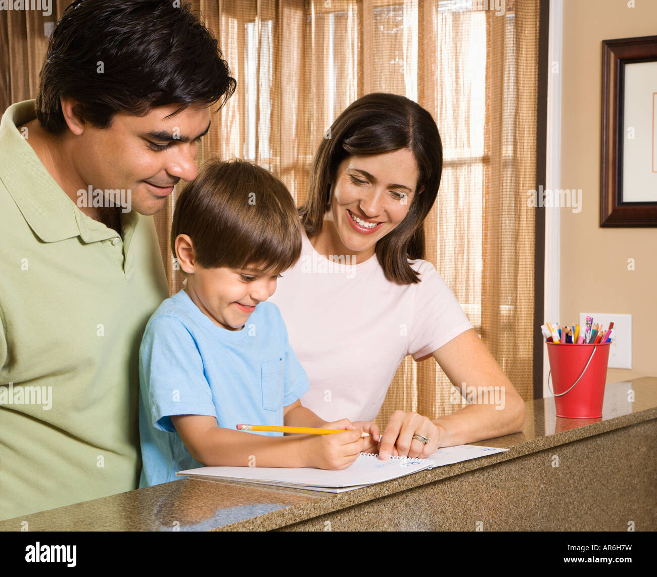 Hispanic parents helping son with homework Stock Photo - Alamy