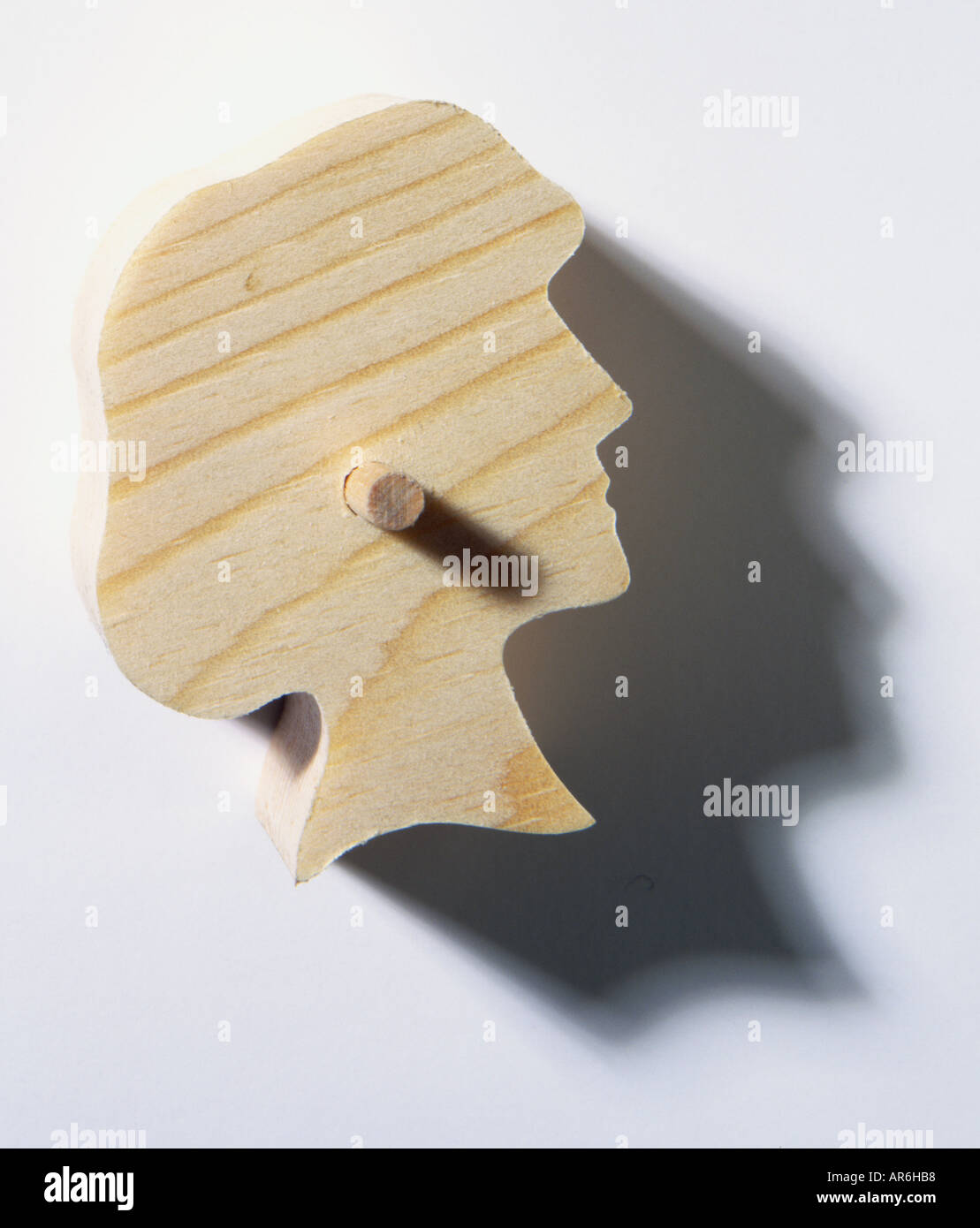 Wooden cut-out template of woman's face in profile, wooden peg in ...