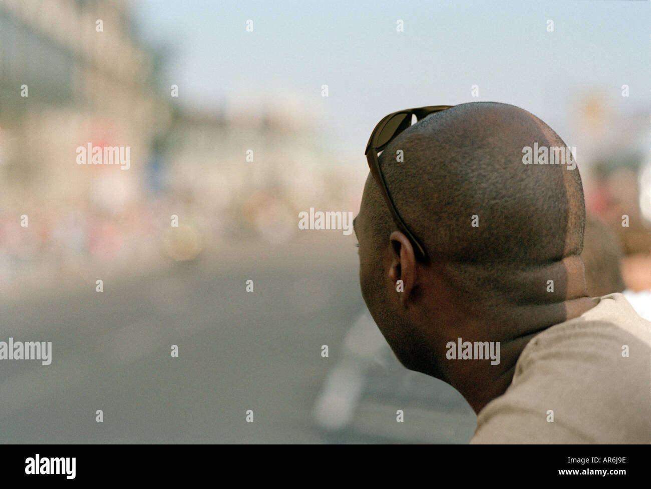 back view of young black man looking down a city street Stock Photo - Alamy