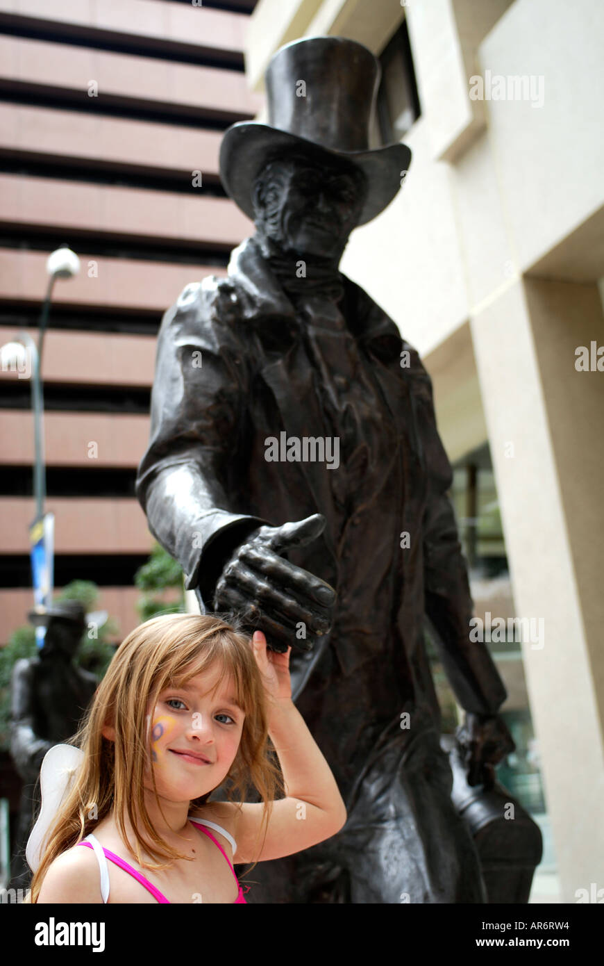 4 year old female child holding hands with statue Stock Photo - Alamy