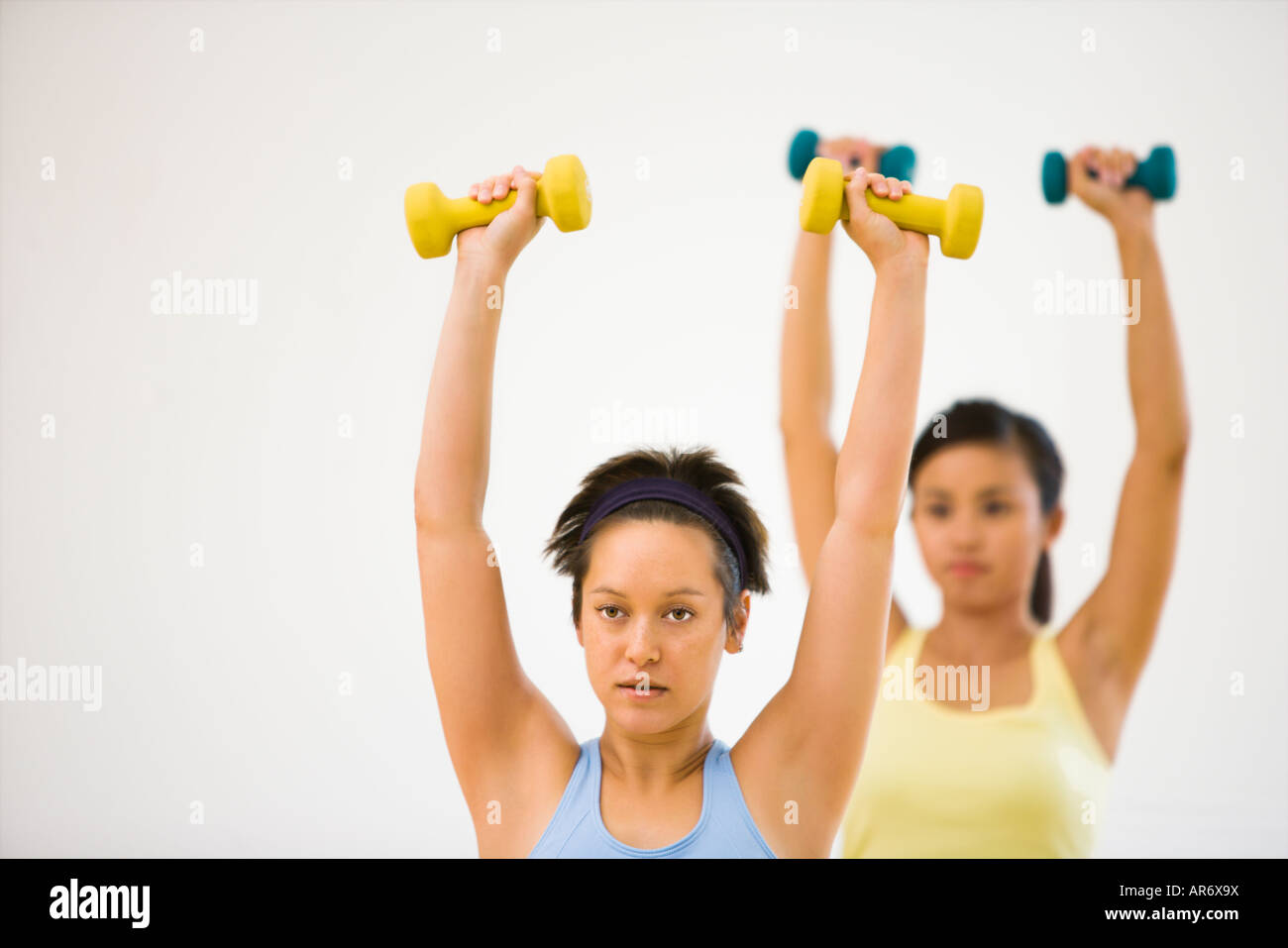 Young women at gym lifting hand weights Stock Photo - Alamy