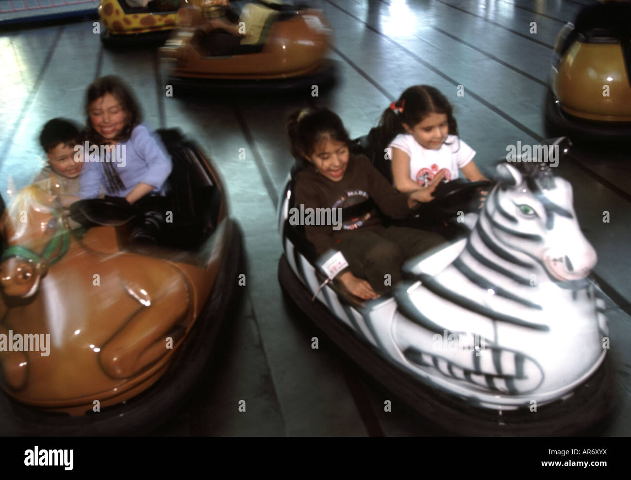 Jordanian children on animal themed bumper cars at amusement park in ...