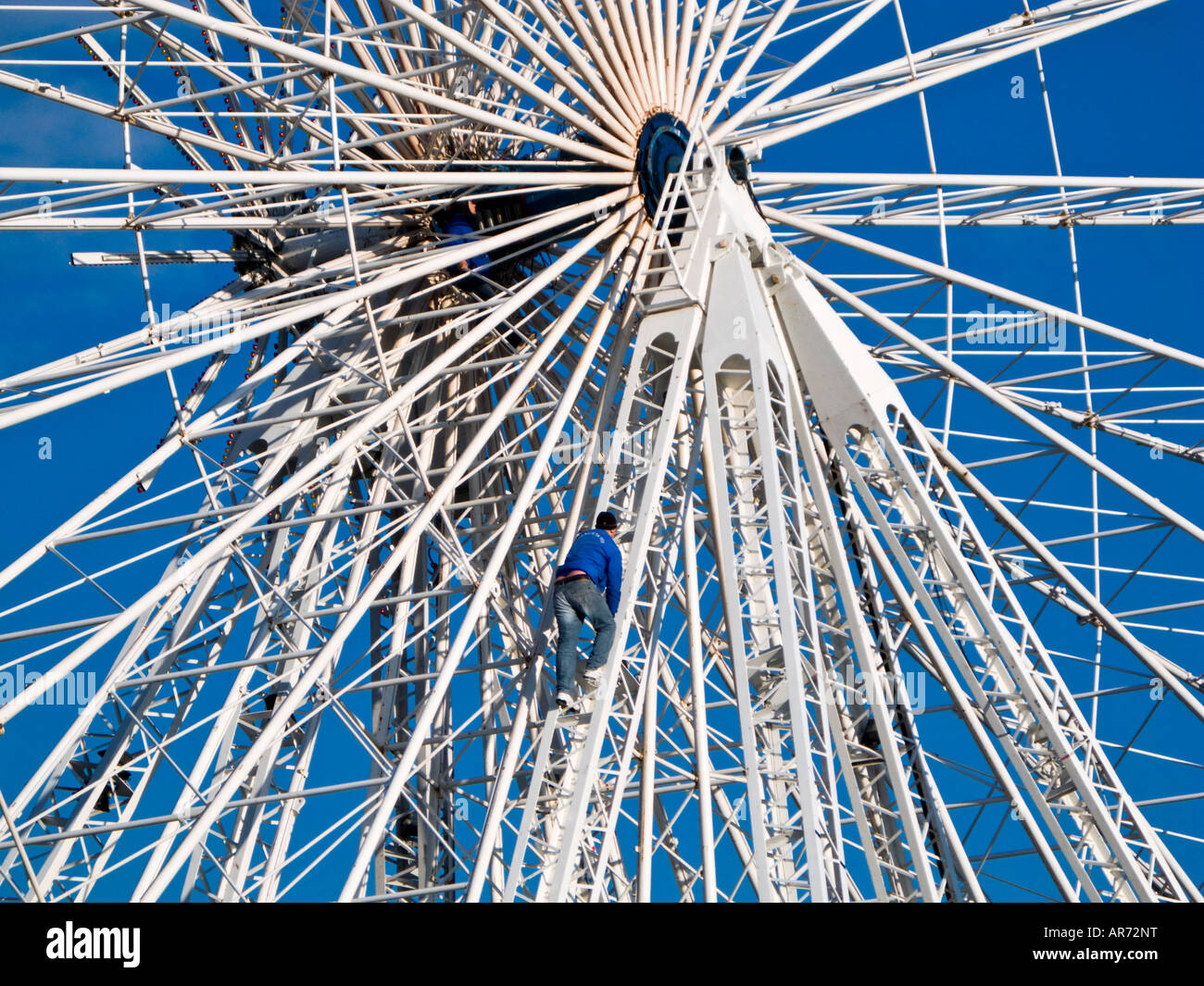 Maintenance man climbs the large Ferris Wheel in "Place de la Concorde ...