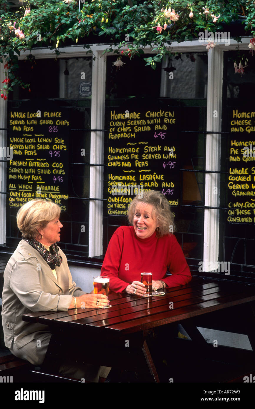 Retired senior women tourists relaxing with beer in restaurant at ...