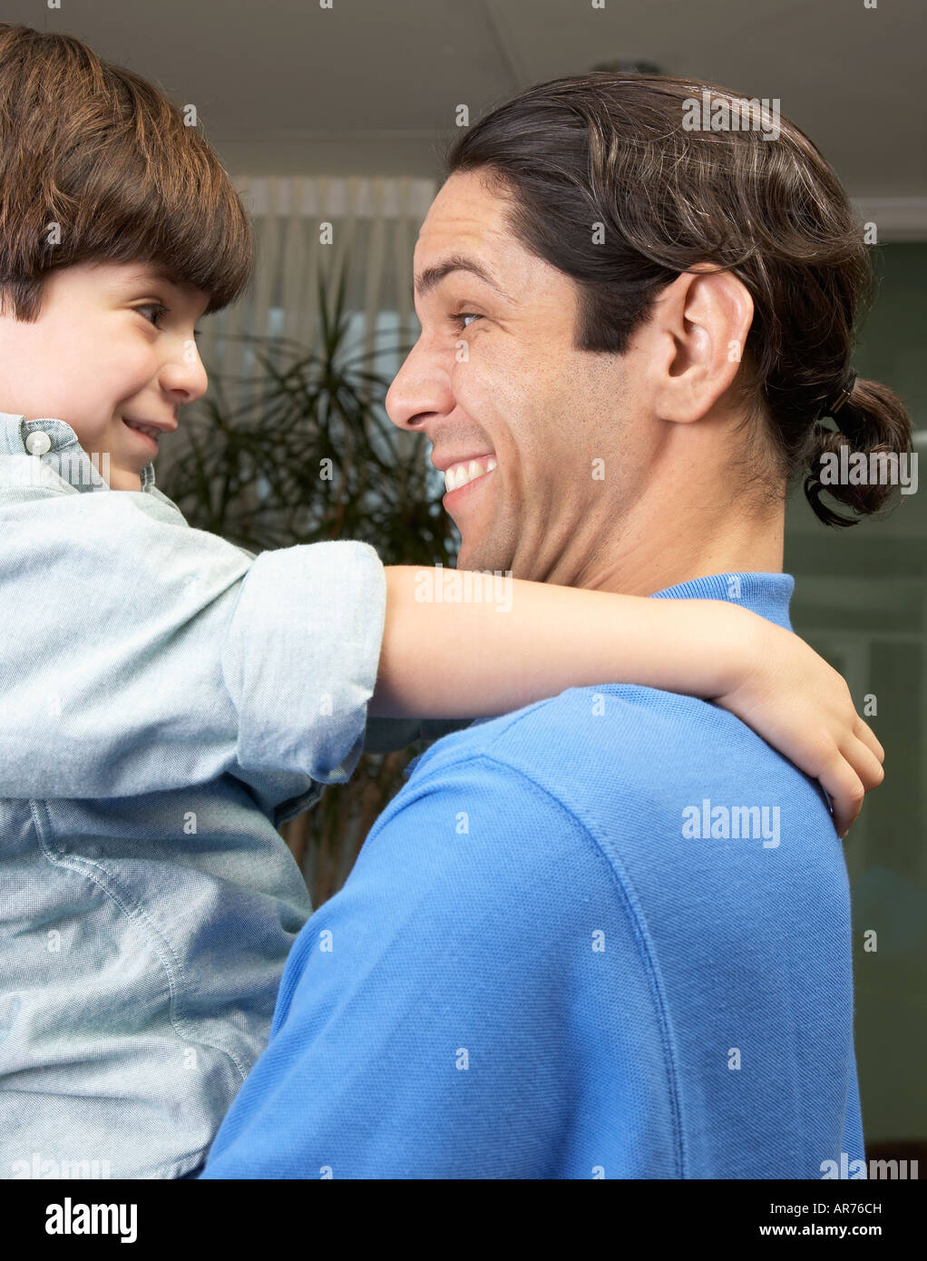 Hispanic father and son smiling at each other Stock Photo - Alamy