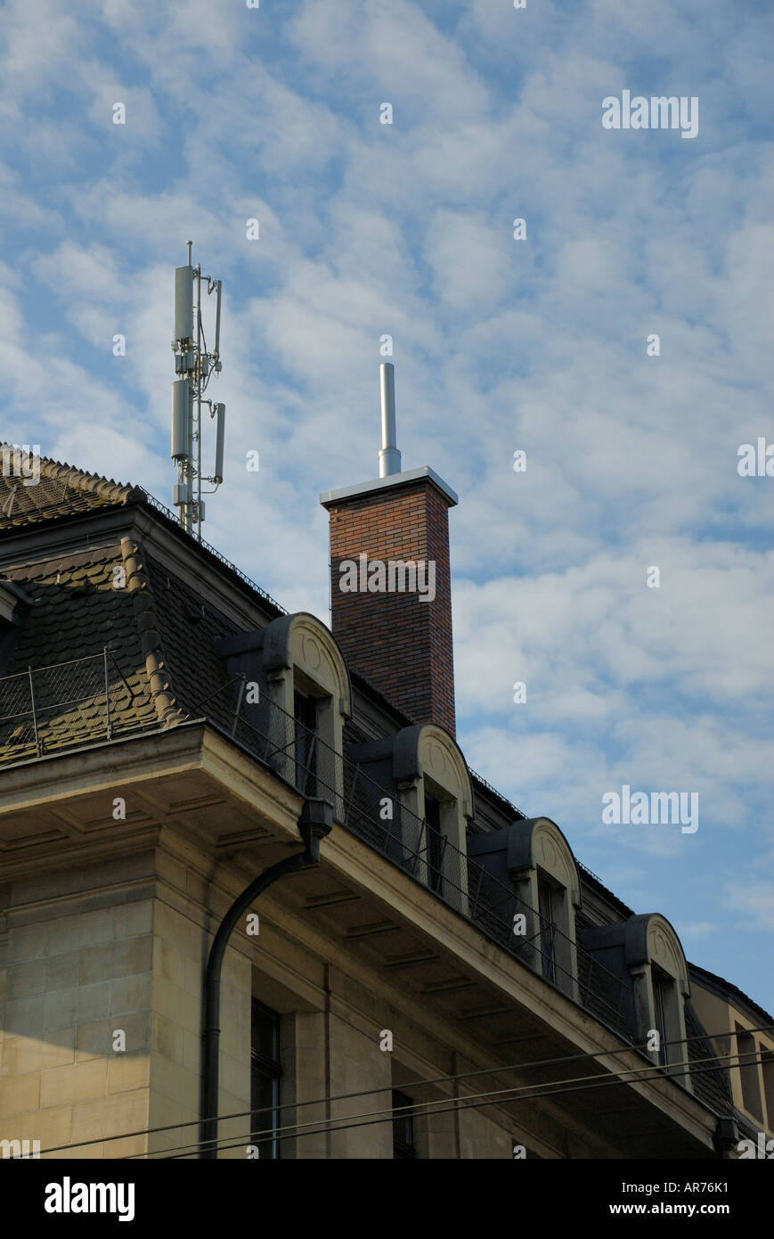 antenna for cellular phone transmission and chimney on a house roof. (c ...