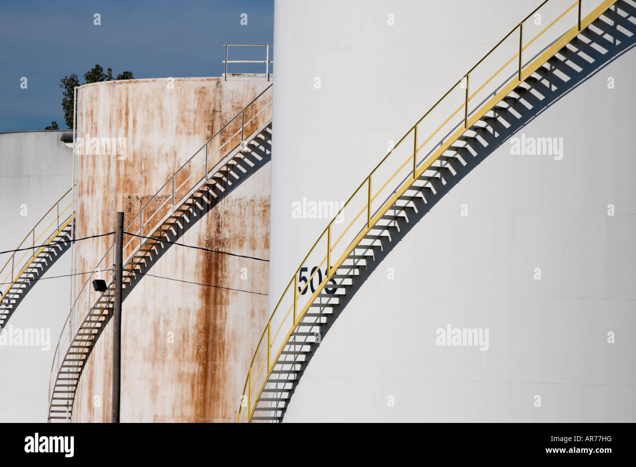 Oil or gasoline storage tanks in an industrial setting with steps and ...